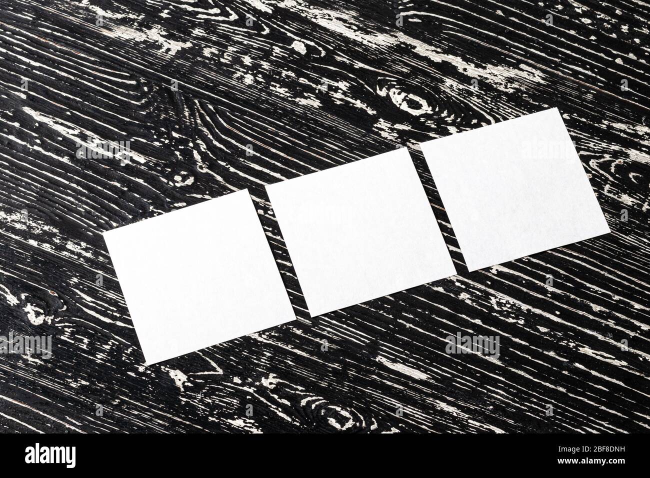 White paper sheets on a black wooden table. Abstract background for ...
