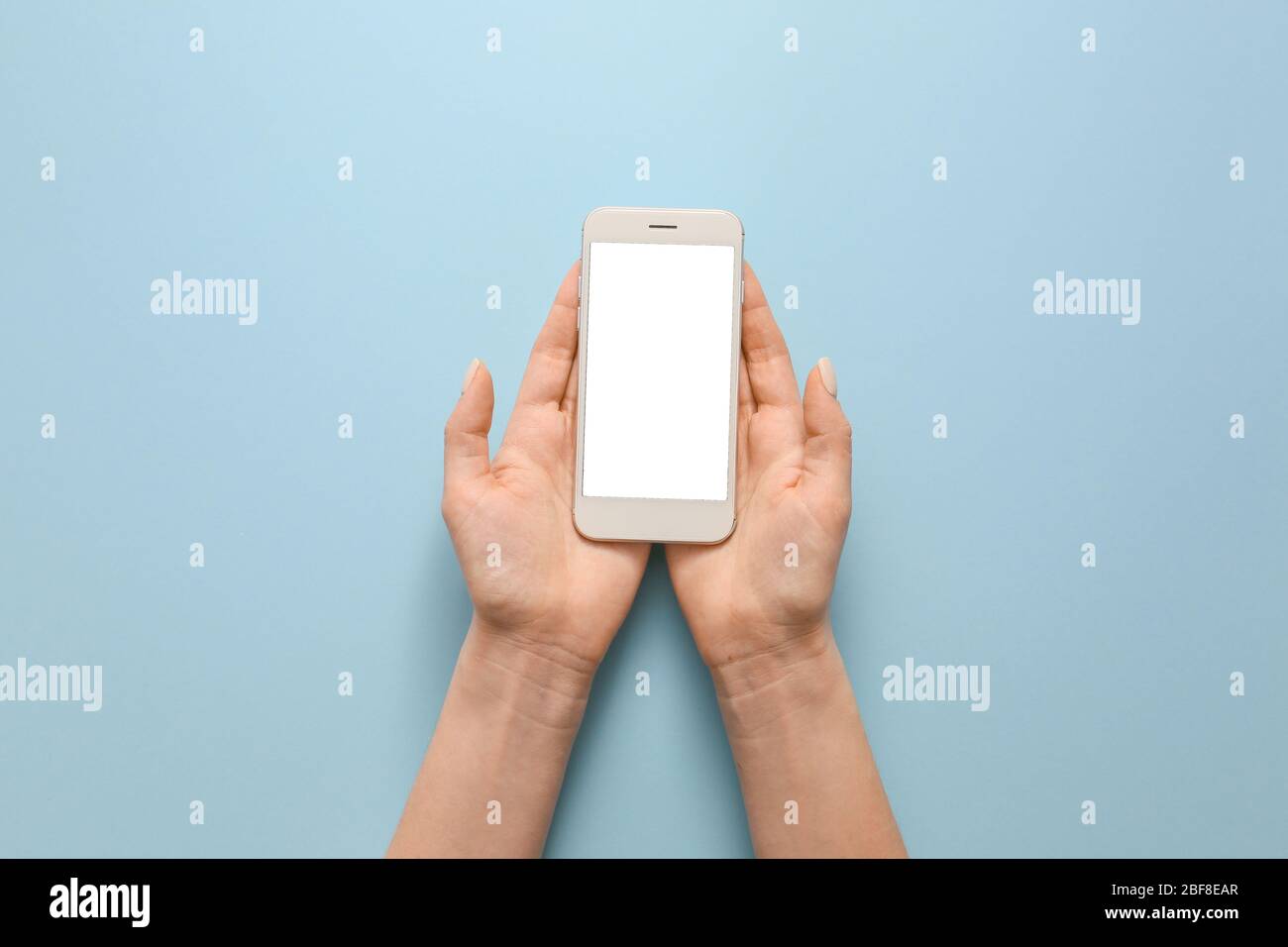 Female hands with mobile phone on color background Stock Photo - Alamy