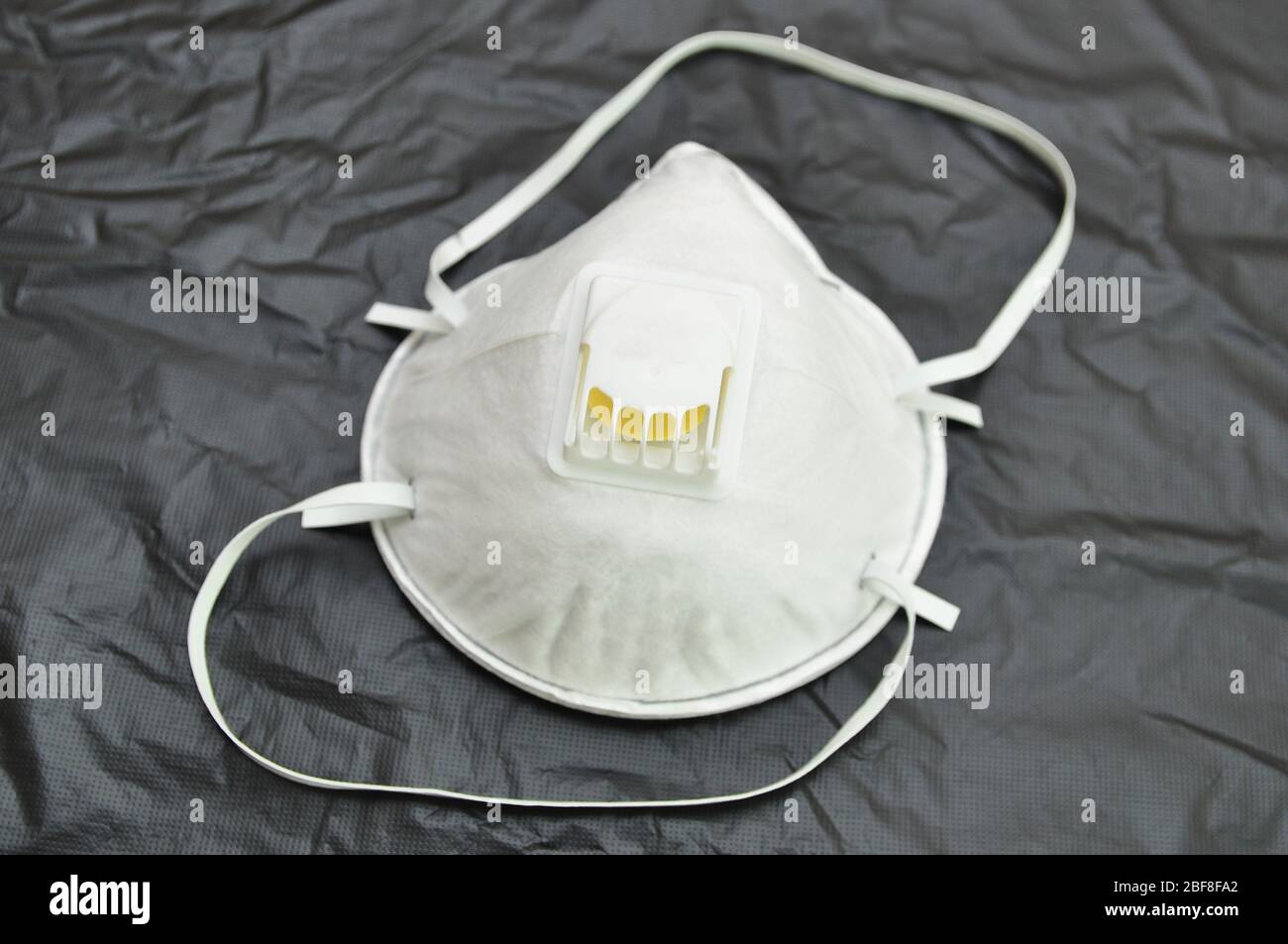 White mask on a black background. respirator with ventilation valve ...