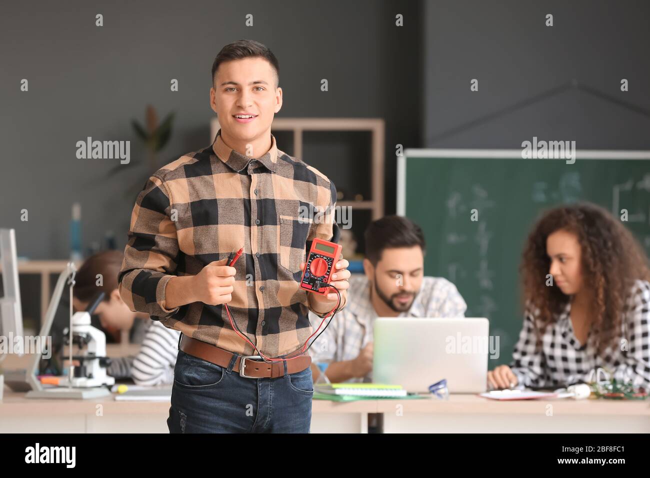 Young man at physics lesson in classroom Stock Photo - Alamy