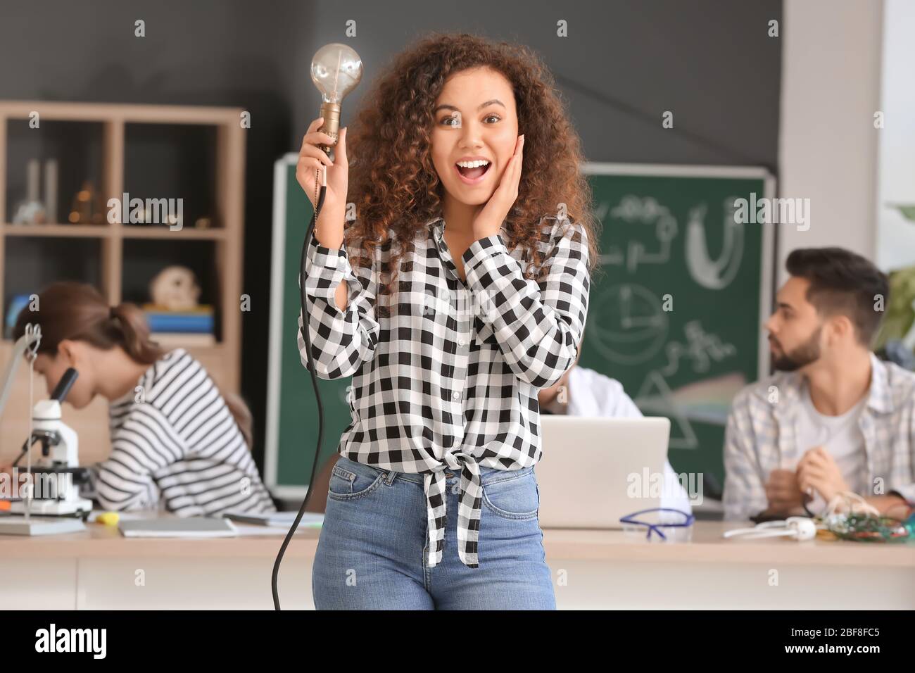 Young woman at physics lesson in classroom Stock Photo - Alamy