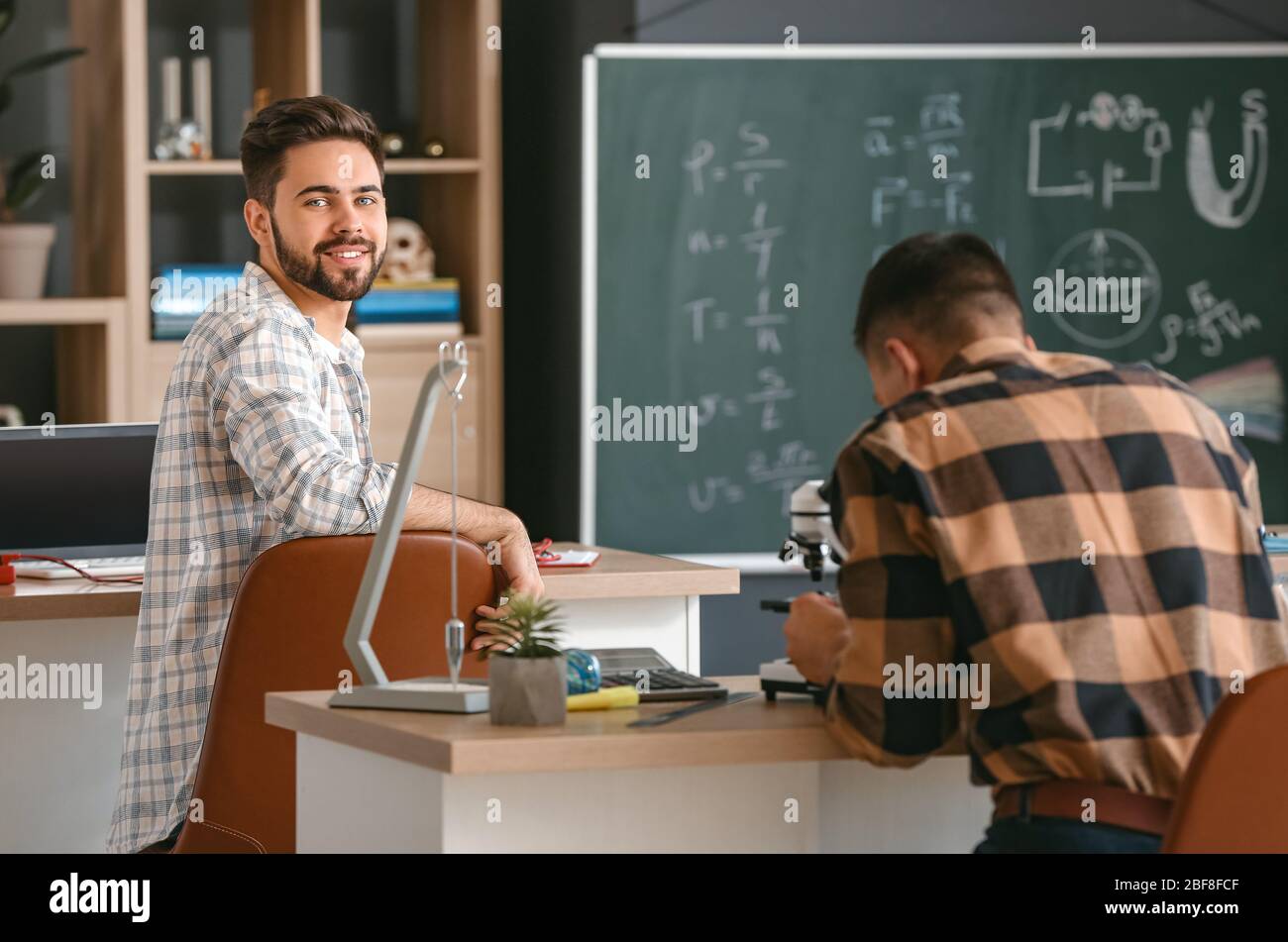 Young man at physics lesson in classroom Stock Photo - Alamy