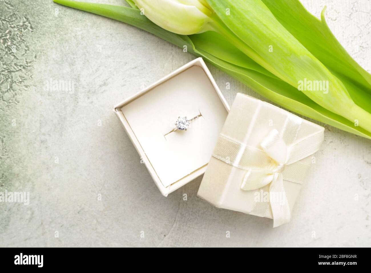 Box with beautiful engagement ring on light background Stock Photo - Alamy