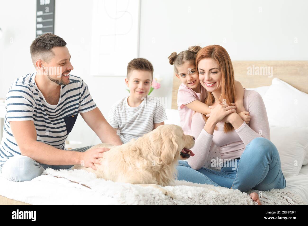 Happy family with dog in bedroom at home Stock Photo - Alamy