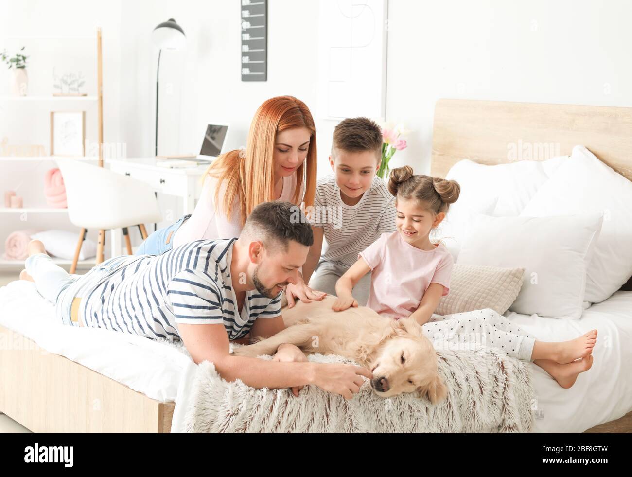 Happy family with dog in bedroom at home Stock Photo - Alamy