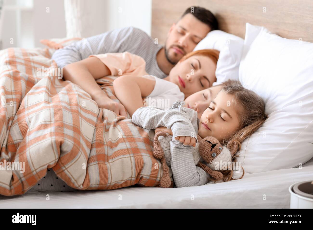 Happy family sleeping in bed at home Stock Photo - Alamy