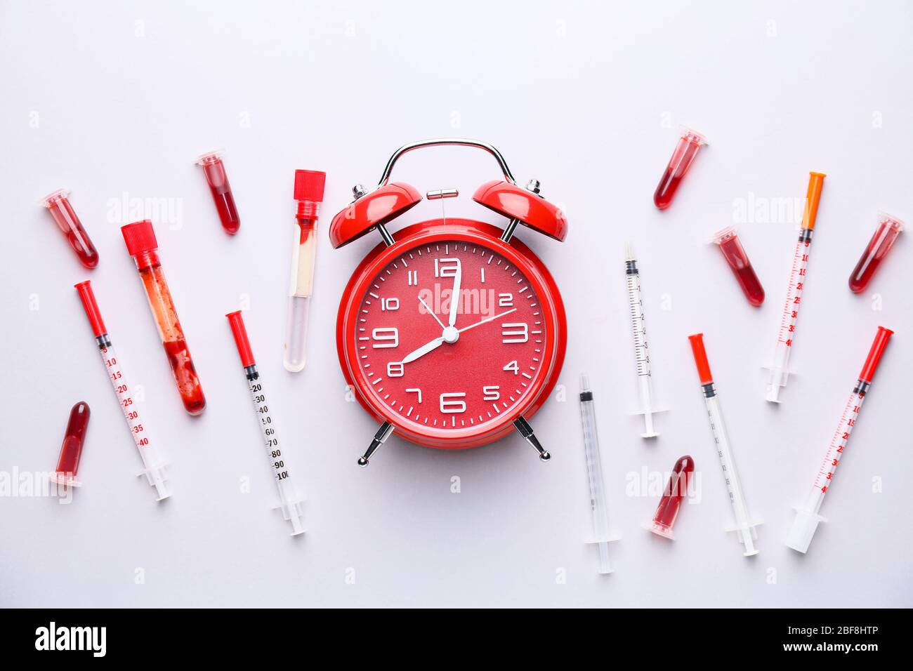Test tubes with blood samples, alarm clock and vaccine for Coronavirus ...
