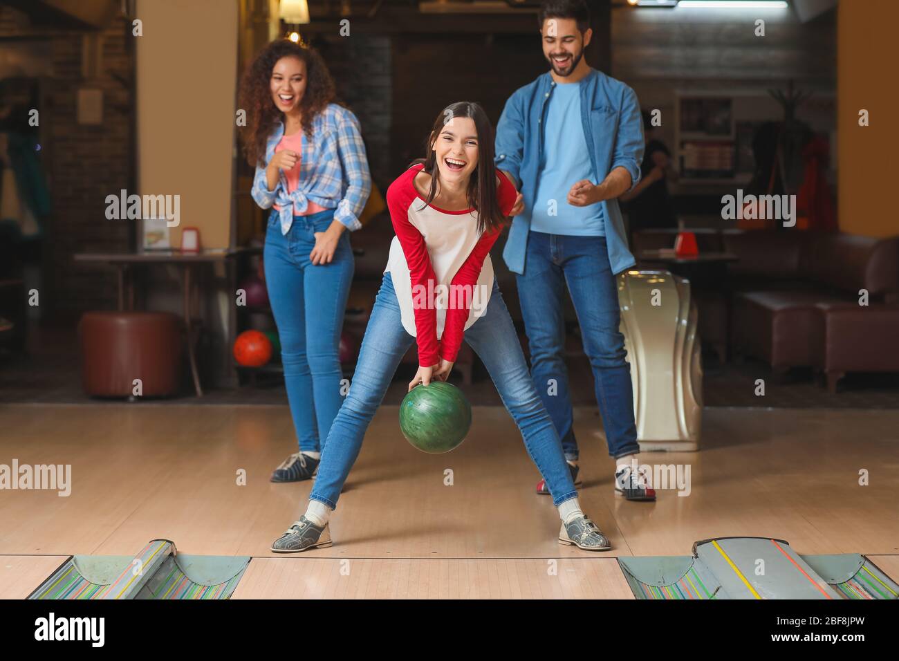 Friends playing bowling in club Stock Photo - Alamy