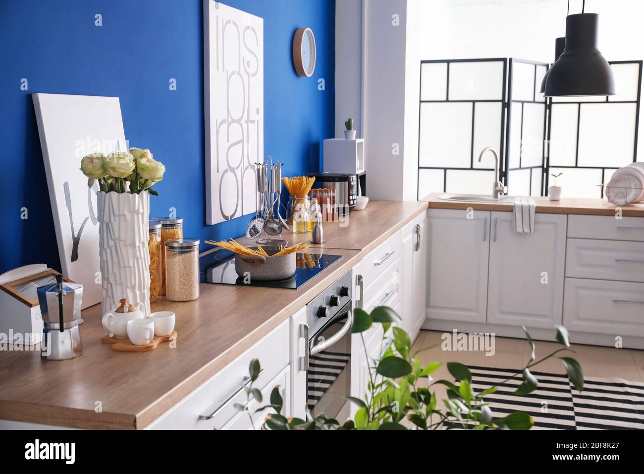 Interior of modern kitchen with blue wall Stock Photo - Alamy