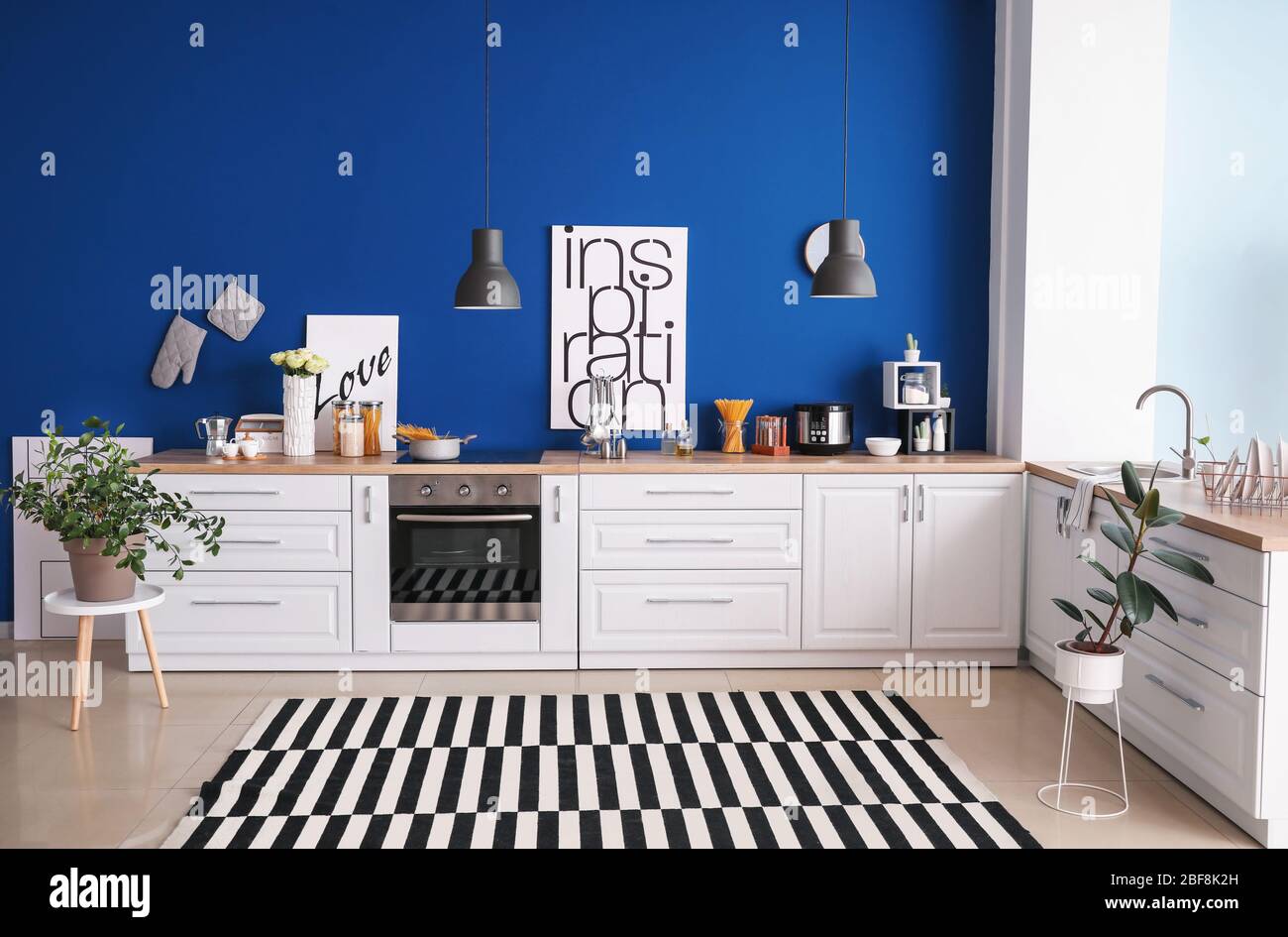 Interior of modern kitchen with blue wall Stock Photo - Alamy
