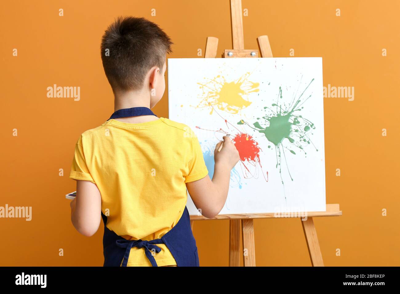 Cute little artist on color background Stock Photo - Alamy