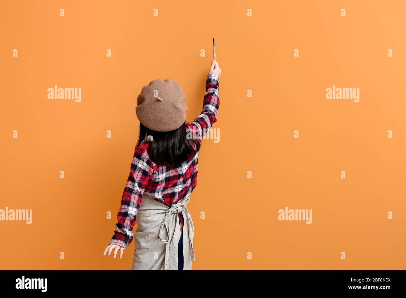Cute little artist on color background Stock Photo - Alamy