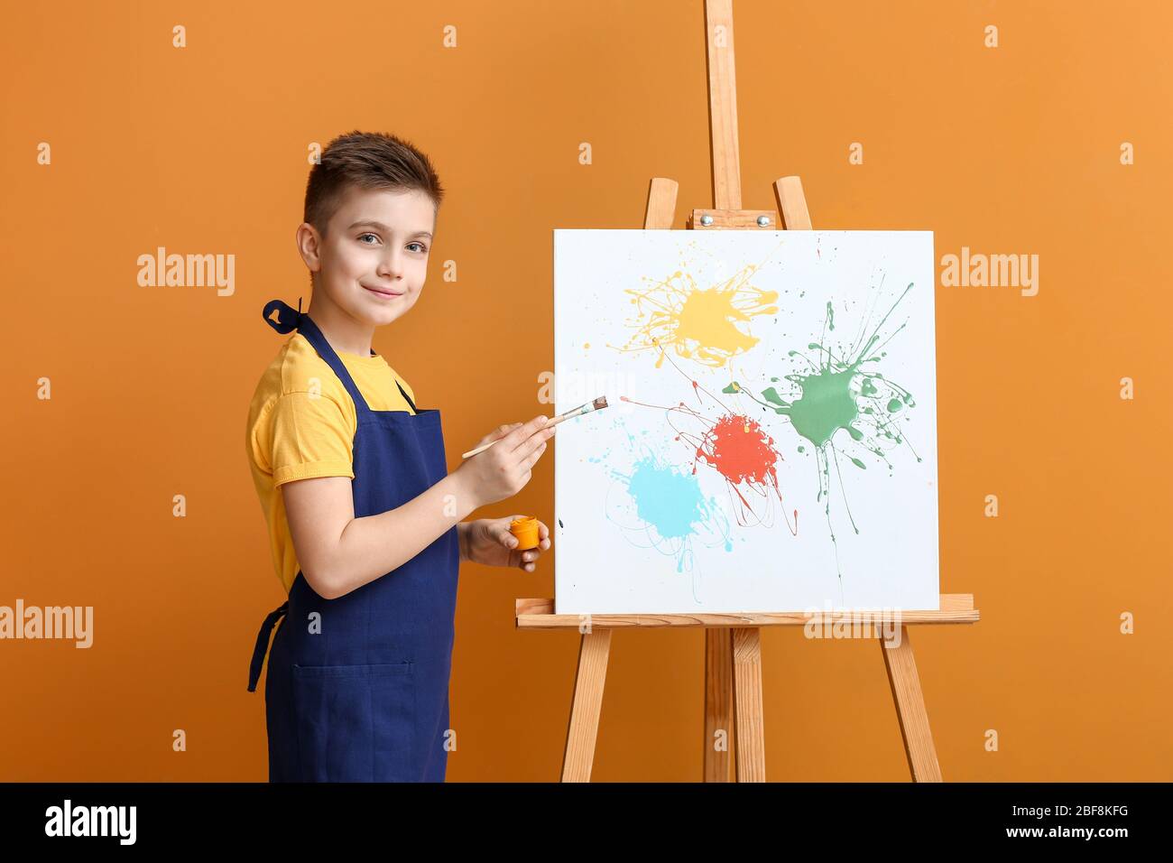 Cute little artist on color background Stock Photo - Alamy