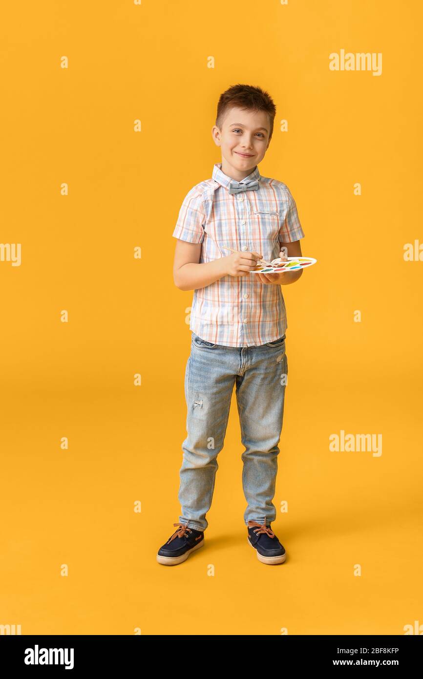 Cute little artist on color background Stock Photo - Alamy