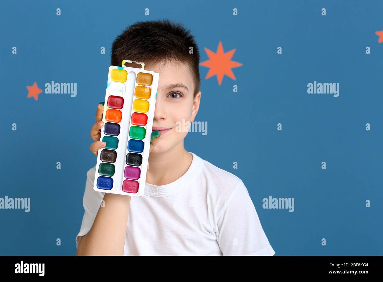 Cute little artist on color background Stock Photo - Alamy