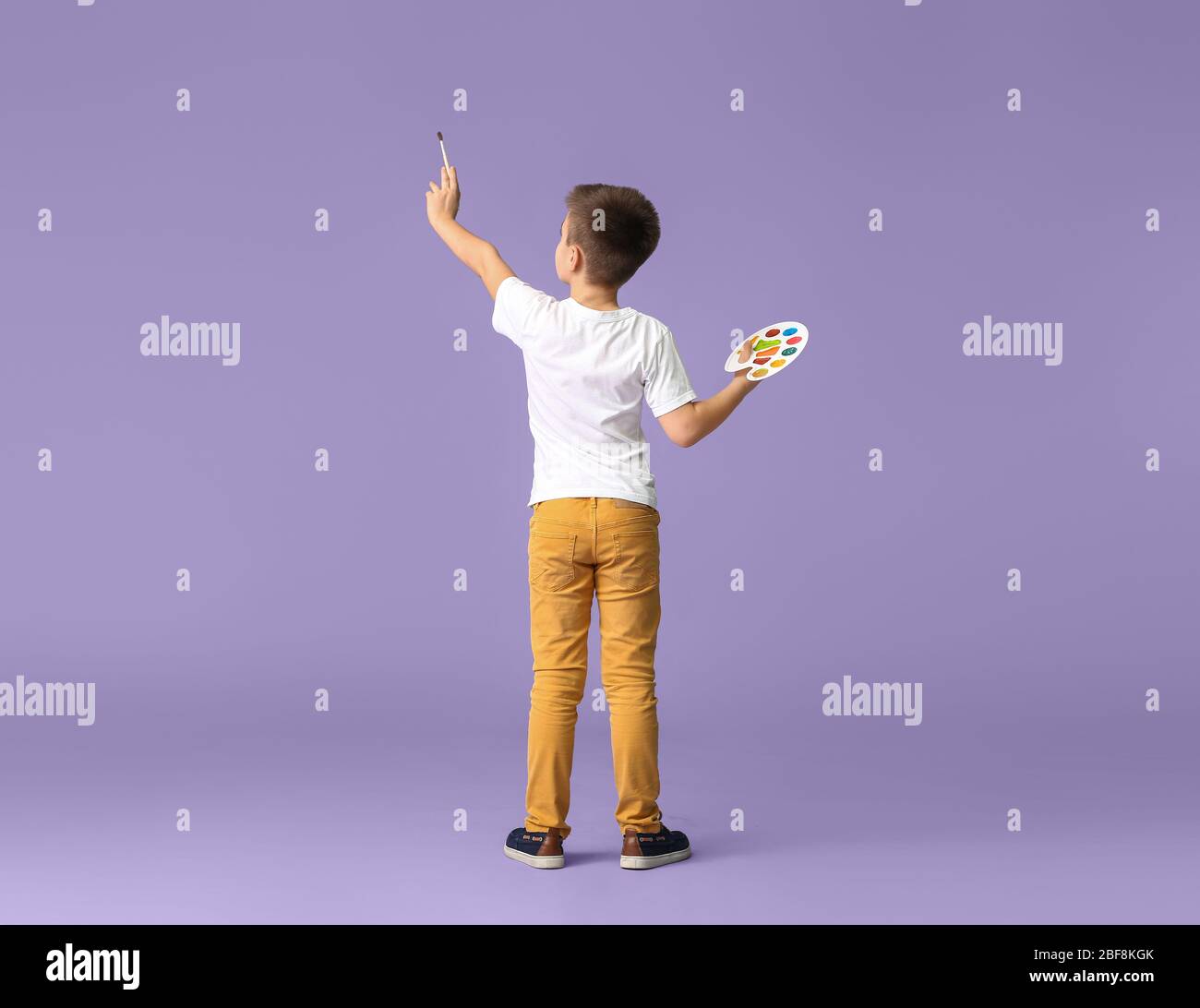 Cute little artist on color background Stock Photo - Alamy