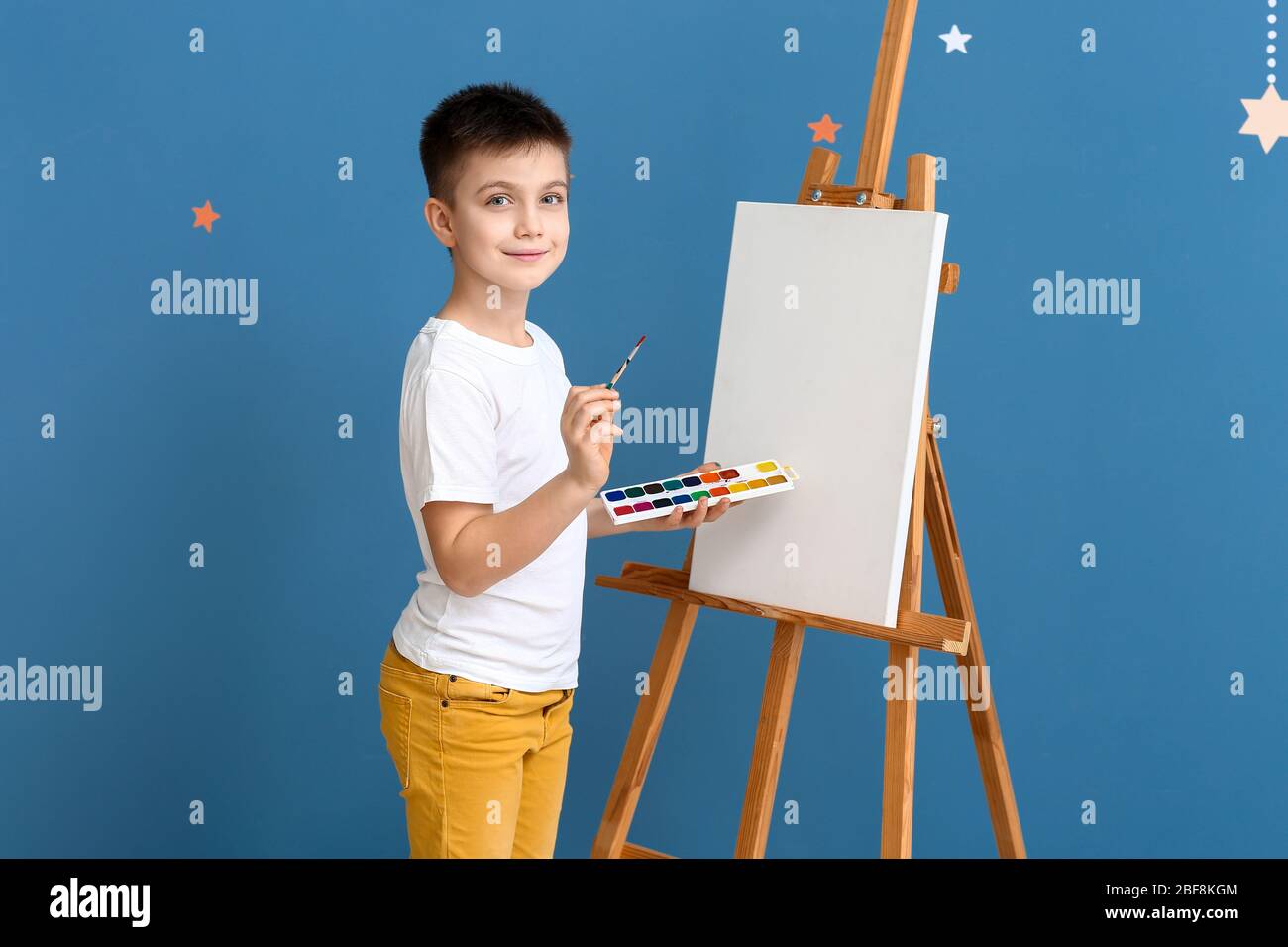 Cute little artist on color background Stock Photo - Alamy