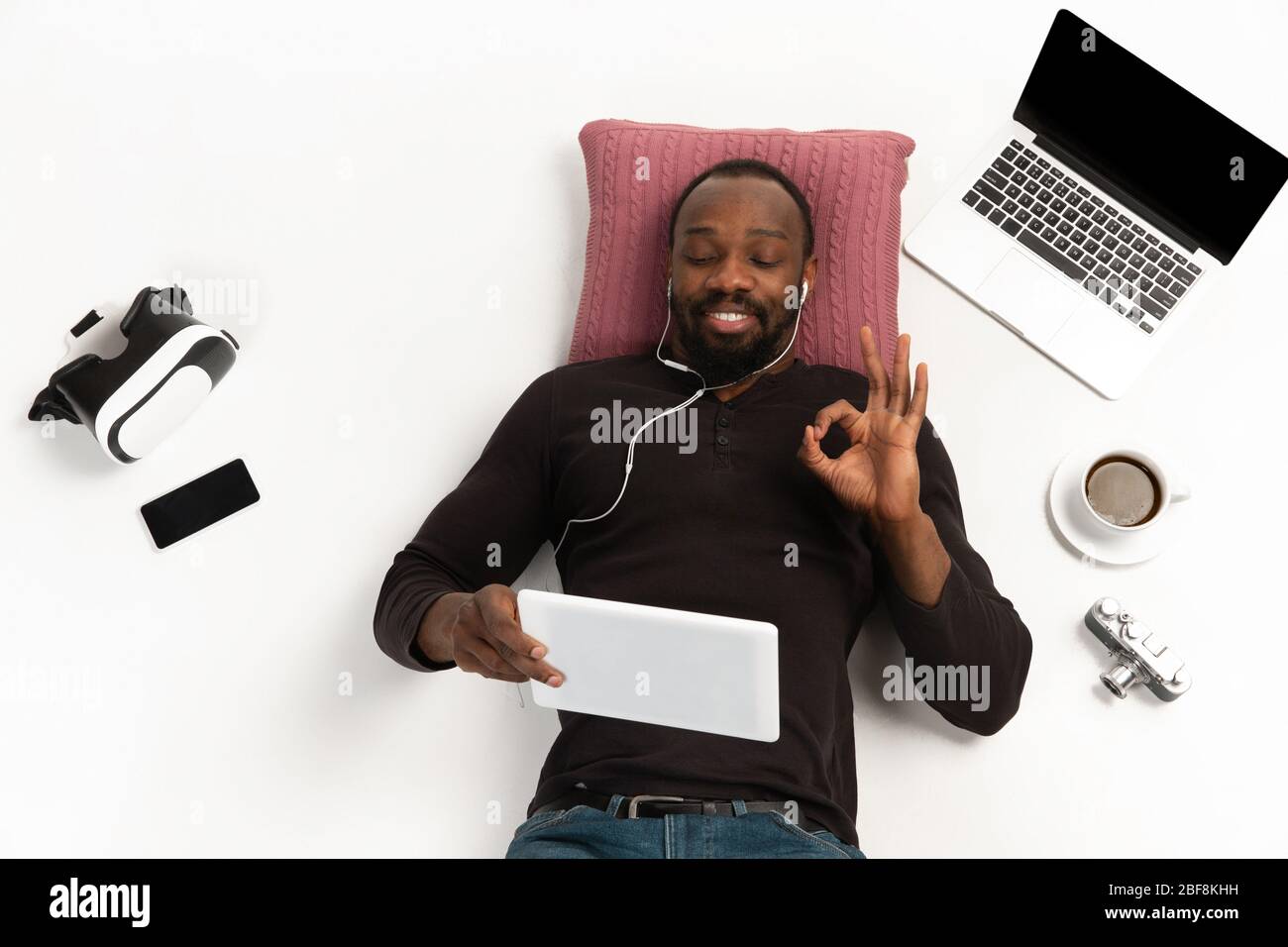 Young african-america man using devices, gadgets isolated on white ...