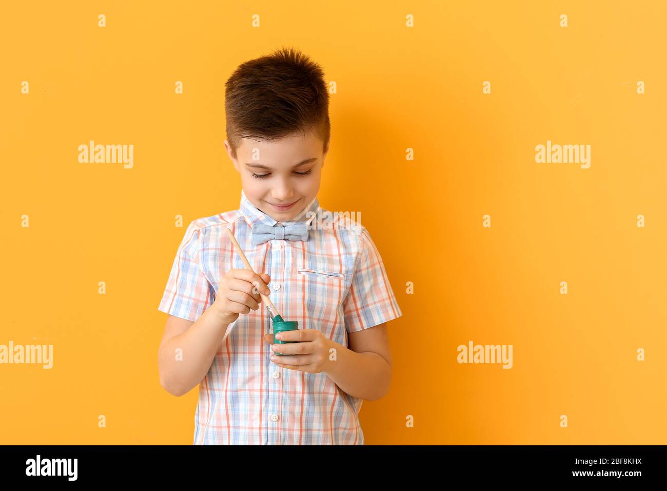 Cute little artist on color background Stock Photo - Alamy