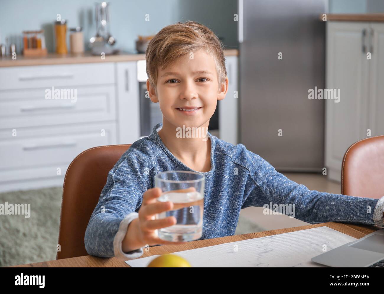 Cute little boy drinking water in kitchen Stock Photo - Alamy