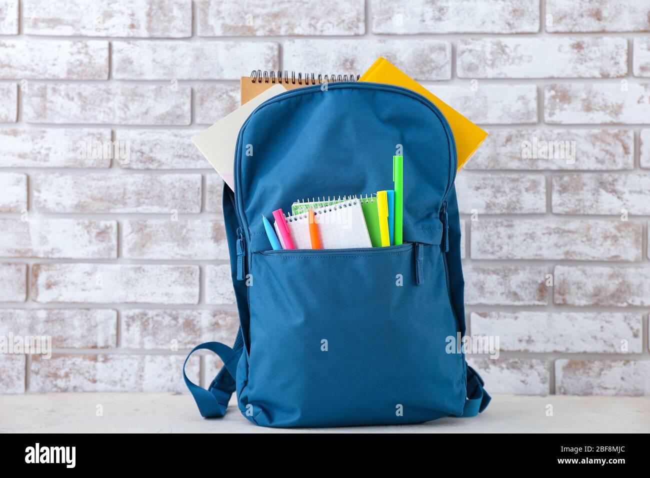School backpack on table near brick wall Stock Photo - Alamy