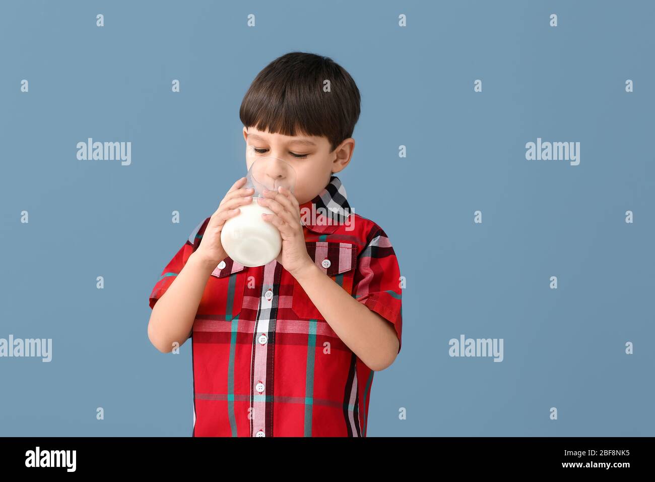 Little boy with milk on color background Stock Photo - Alamy