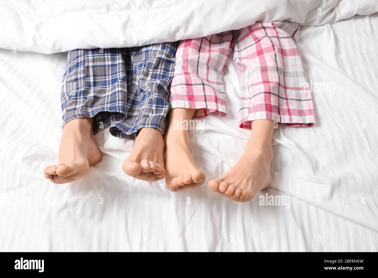 Young couple lying in bed, top view Stock Photo - Alamy