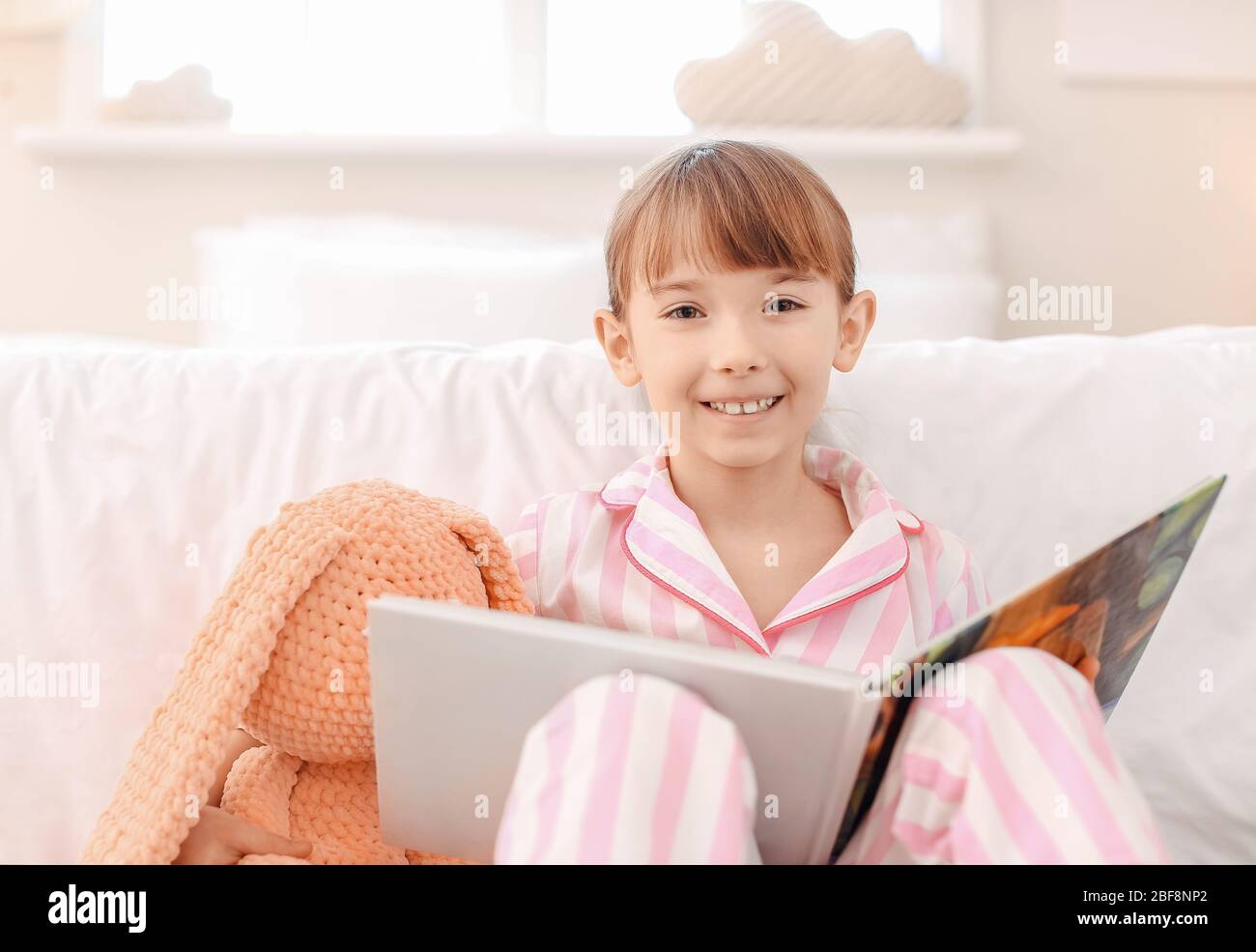 Cute little girl reading bedtime story at home Stock Photo - Alamy