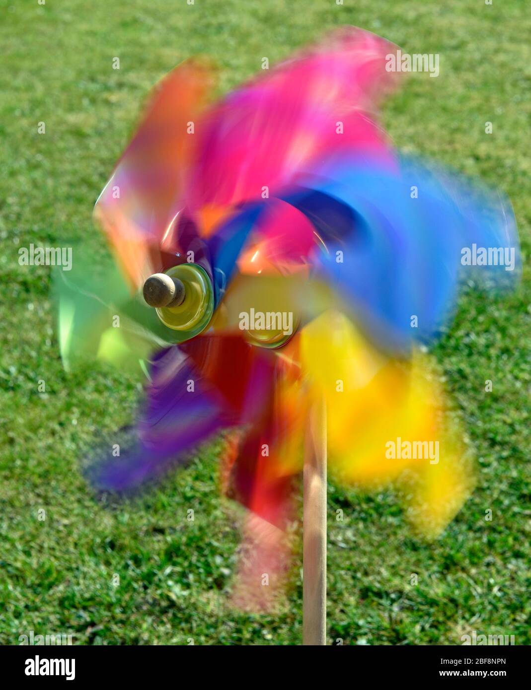 Colourful toy windmill against the sun and a blue sky Stock Photo - Alamy