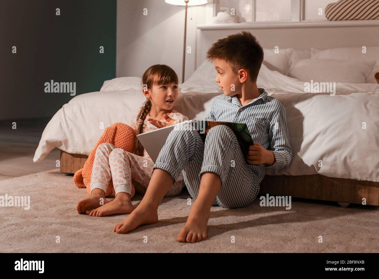 Little children reading bedtime story at home Stock Photo - Alamy