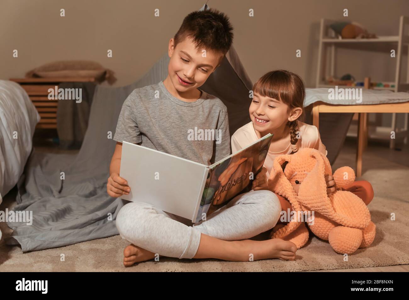 Little children reading bedtime story at home Stock Photo - Alamy