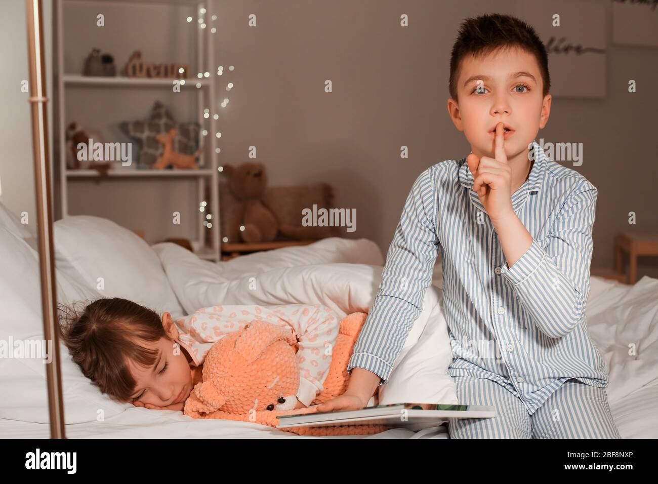 Little girl falling asleep while her brother reading bedtime story at ...