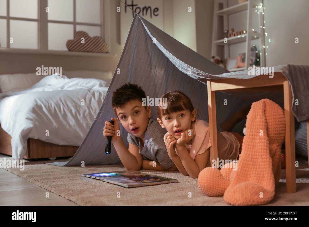 Scared little children reading bedtime story at home Stock Photo - Alamy