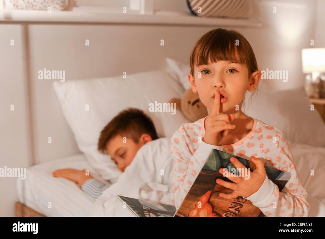 Little Boy Falling Asleep While His Sister Reading Bedtime Story At