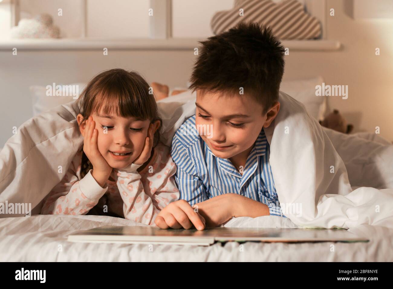 Little children reading bedtime story at home Stock Photo - Alamy
