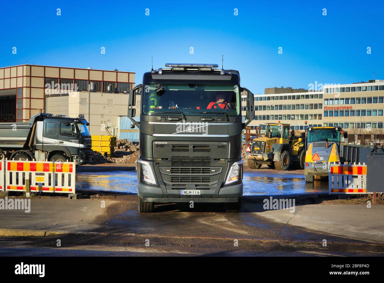 Black Volvo FH tipper truck carrying a load of gravel exits ...