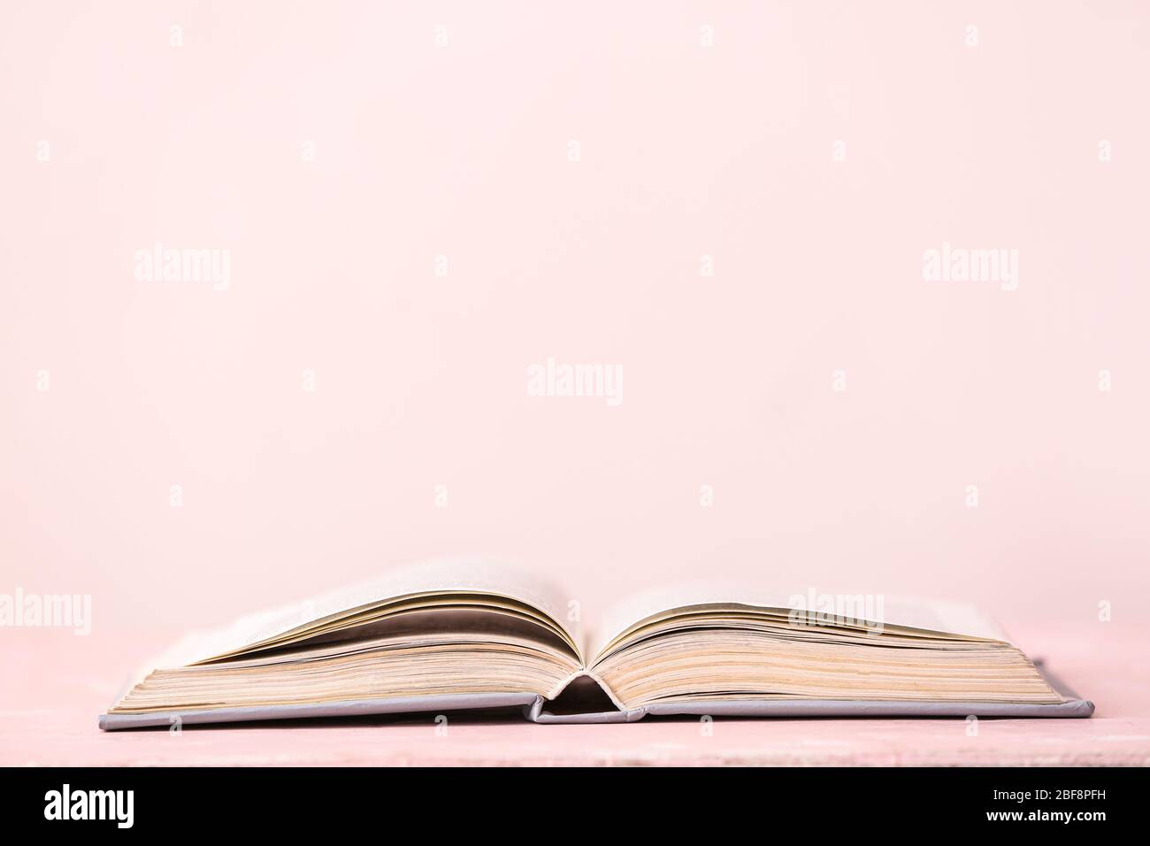 Open book on color background Stock Photo - Alamy
