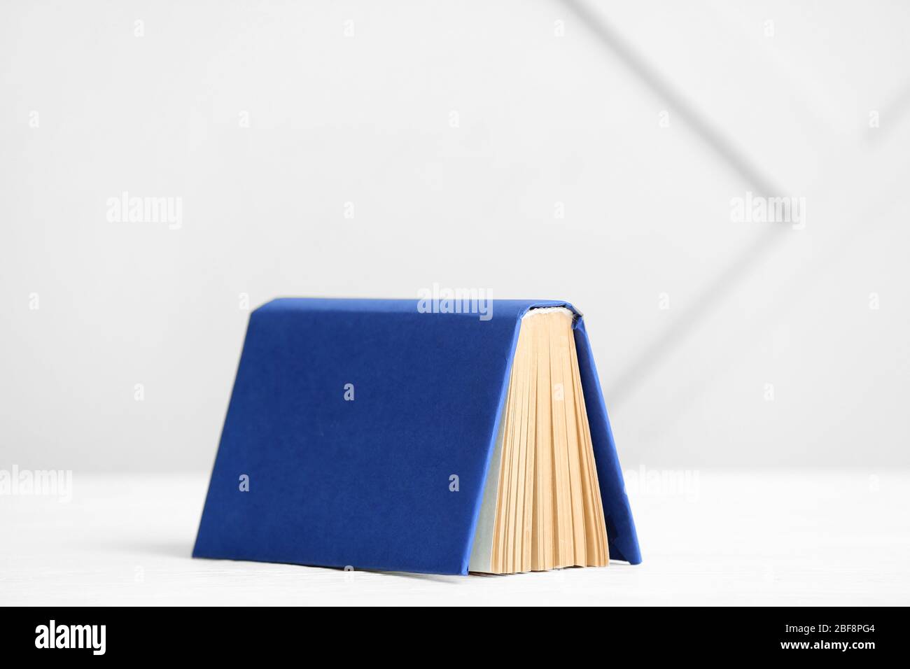 Book on table against light background Stock Photo - Alamy