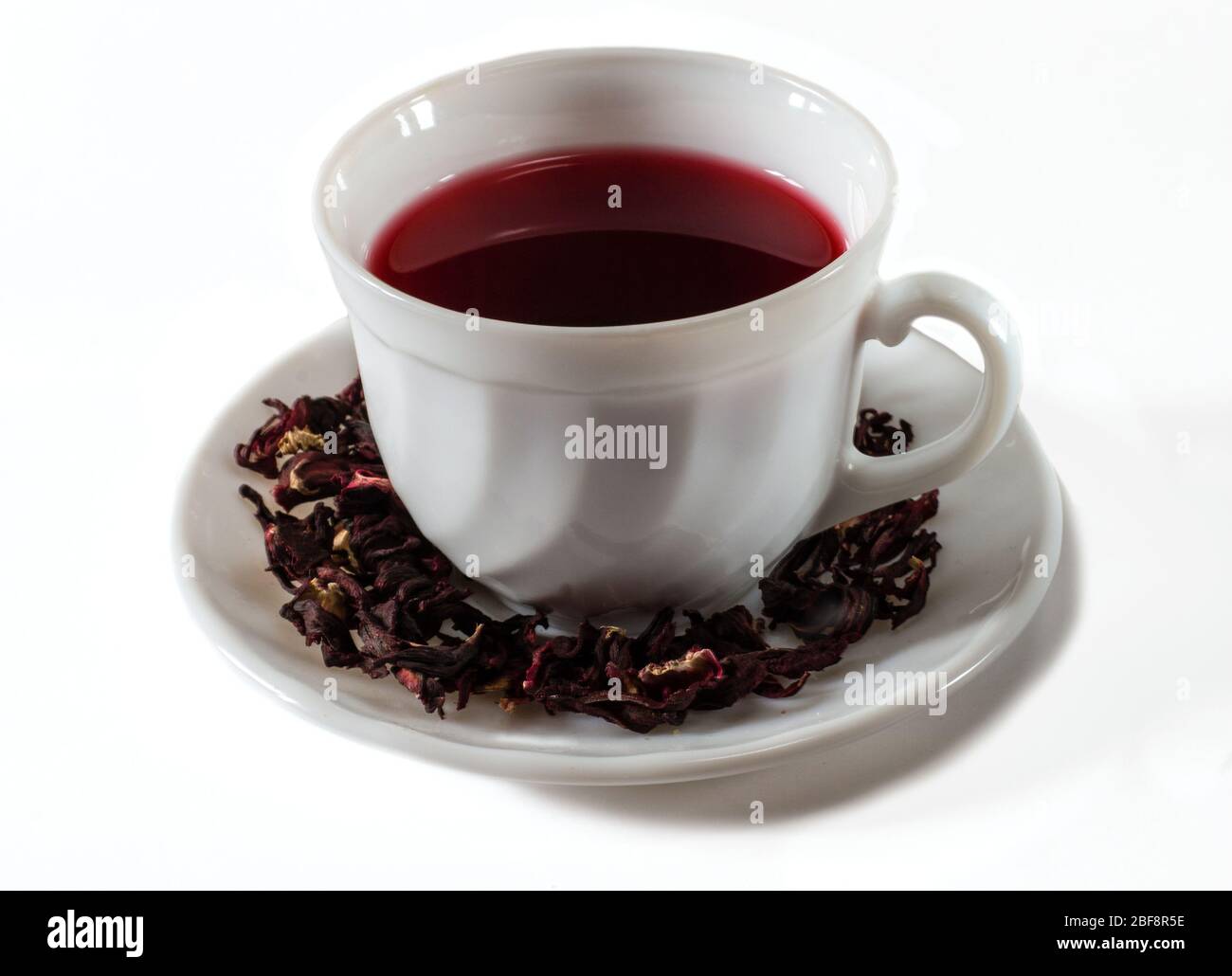 Cup of Karkadeh Red Tea with Dry Flowers isolated on a white background ...