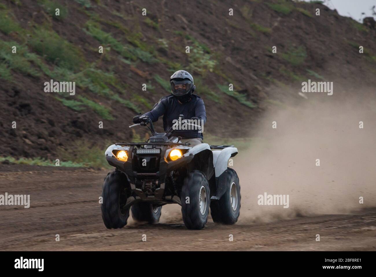 The quad racer is riding on the dirt road. Quad bike off-road. Quad ...