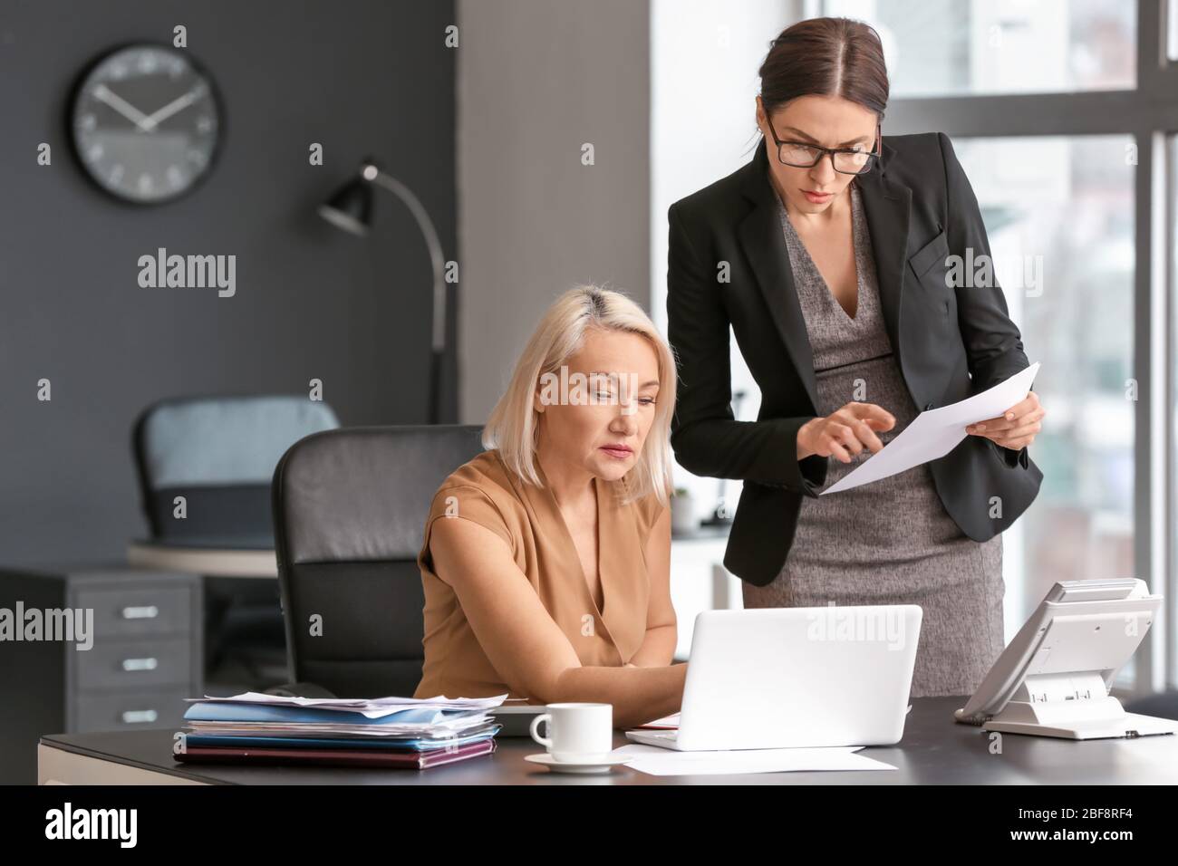 Female accountant and her colleague working in office Stock Photo - Alamy