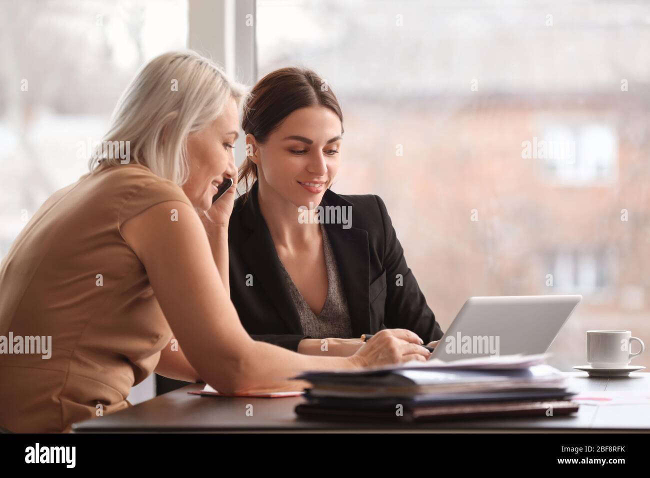 Female accountant and her colleague working in office Stock Photo - Alamy