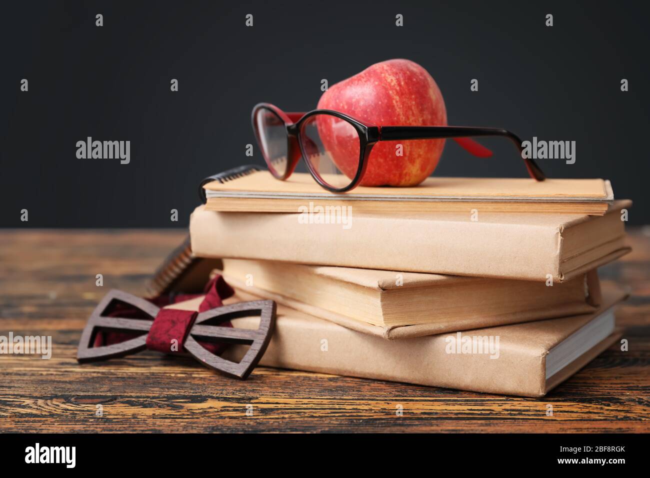 Set of school stationery and apple on table in classroom. Teacher's Day ...