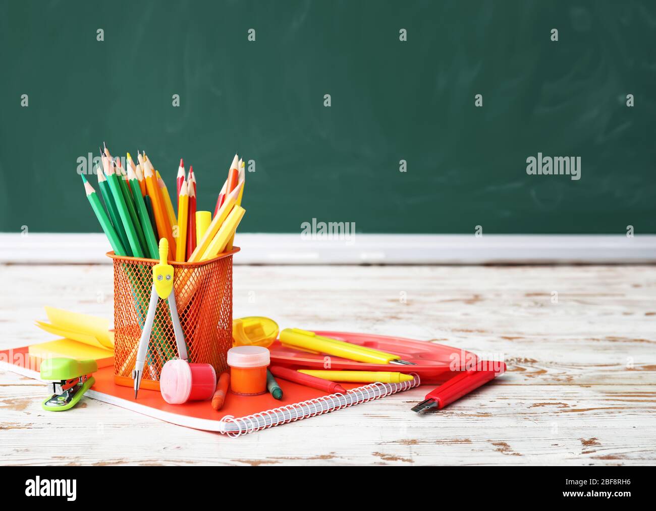 Set of school stationery on table in classroom Stock Photo - Alamy