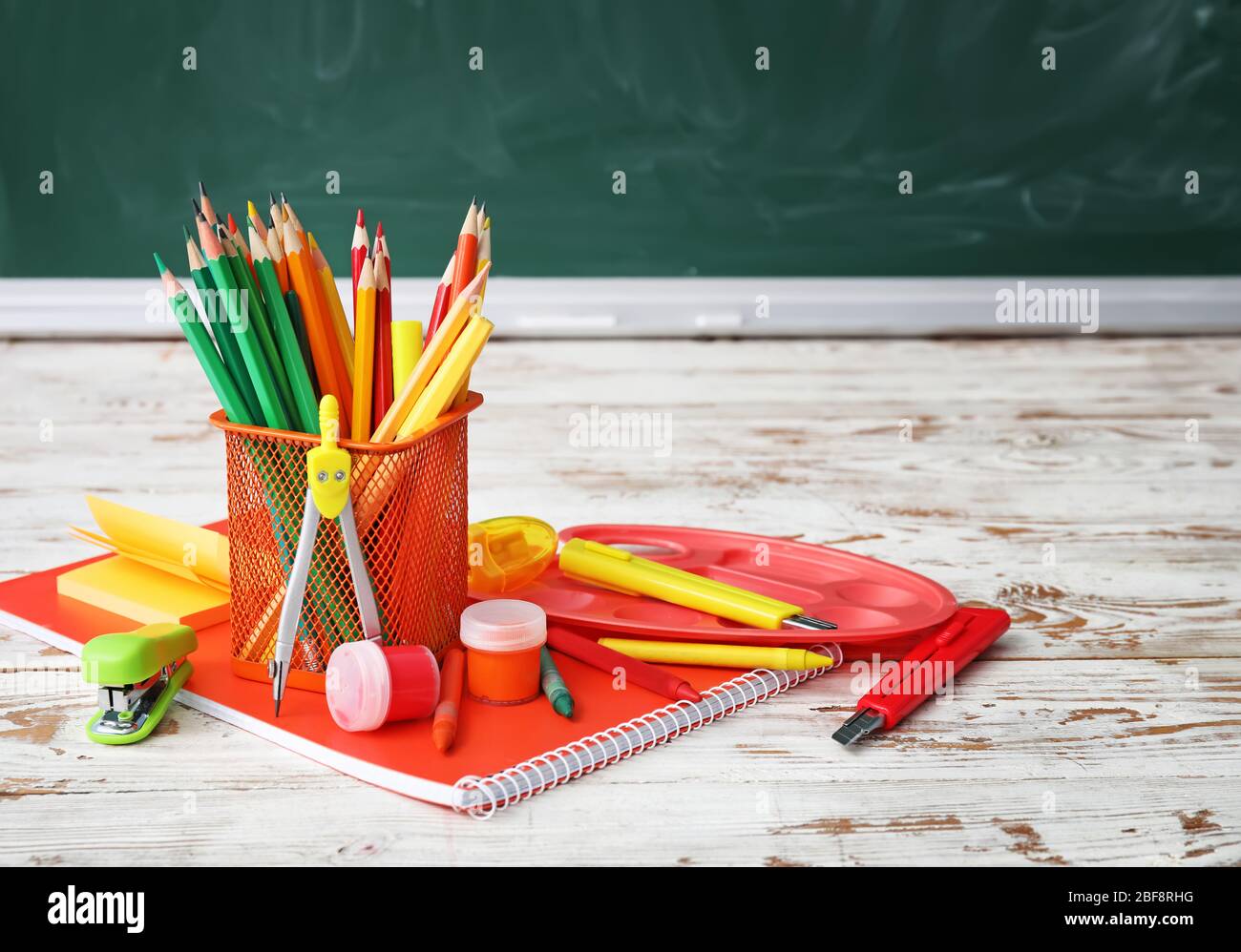 Set of school stationery on table in classroom Stock Photo - Alamy