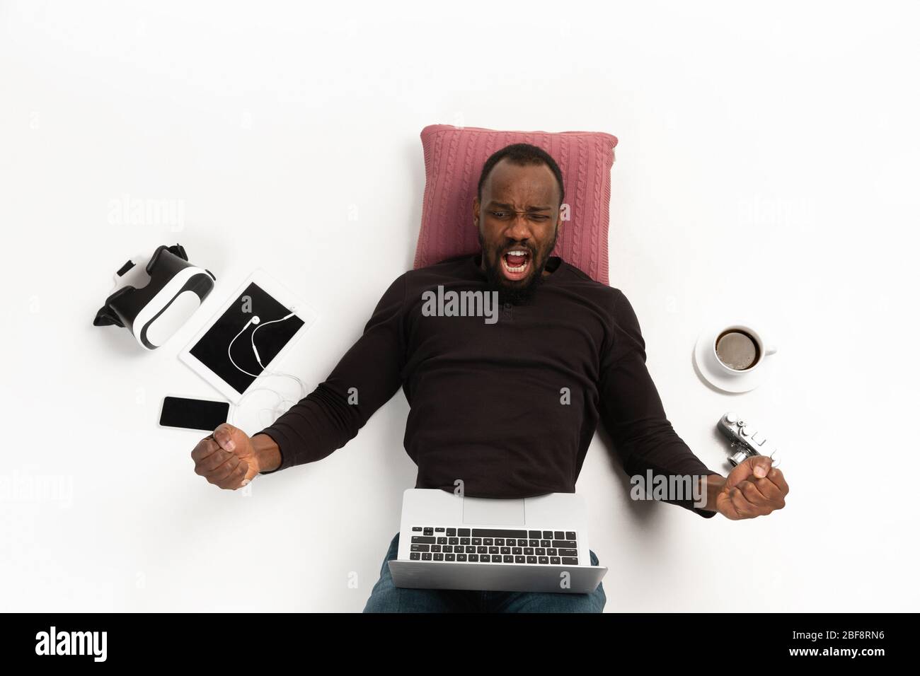 Young african-american man using devices, gadgets isolated on white ...
