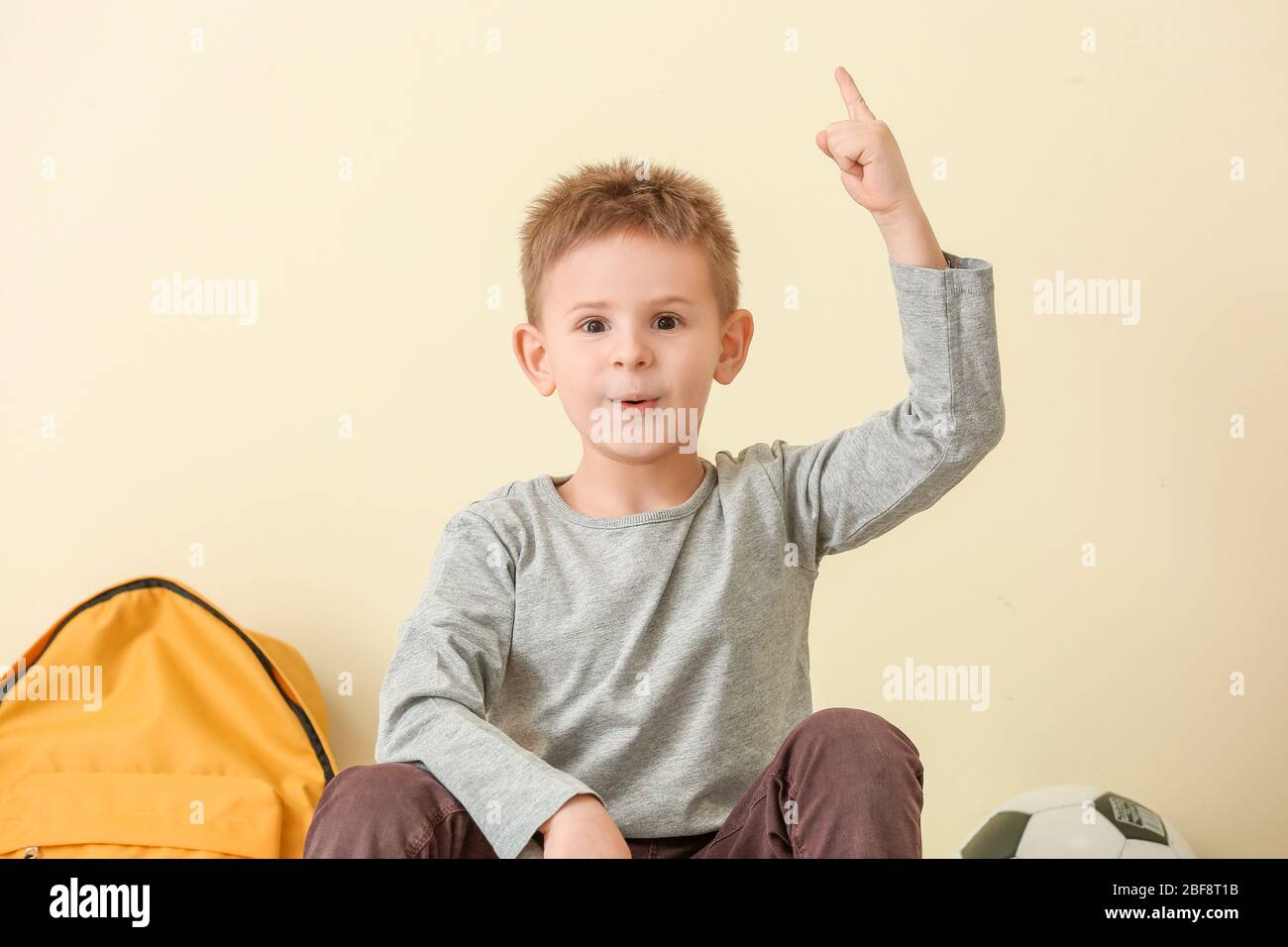 Cute little boy with raised index finger on color background Stock ...