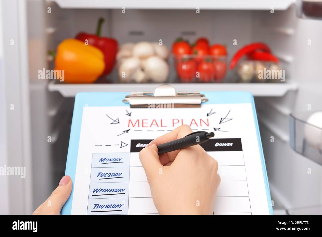 Woman making meal plan in kitchen Stock Photo - Alamy