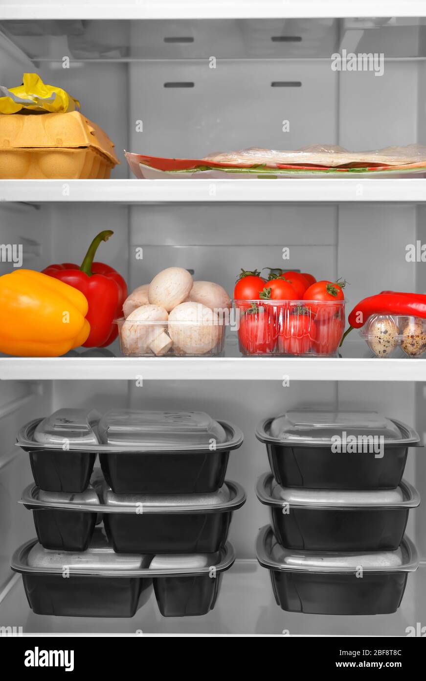 Containers with healthy food on shelf in fridge Stock Photo - Alamy