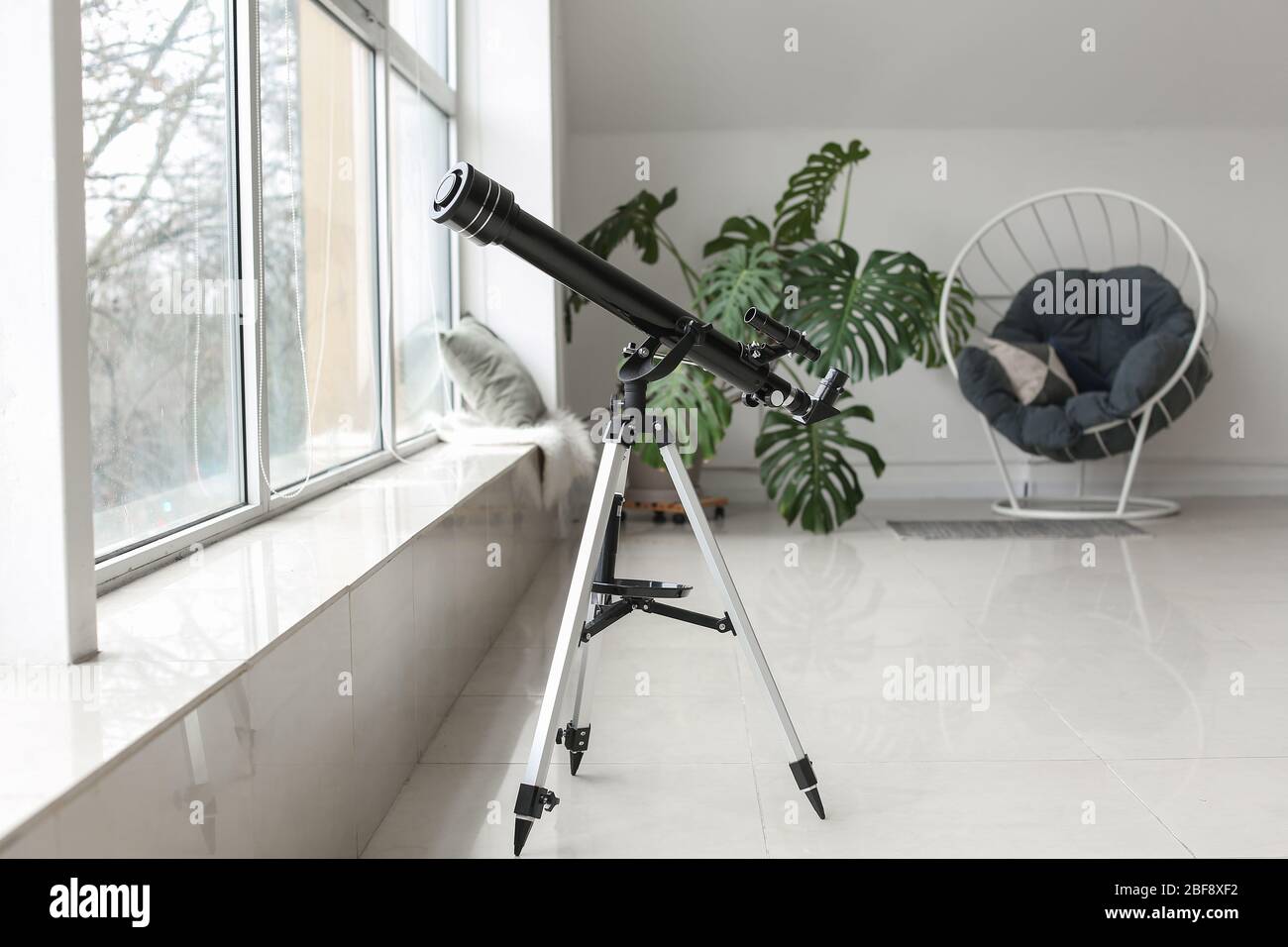 Modern telescope in interior of room Stock Photo - Alamy